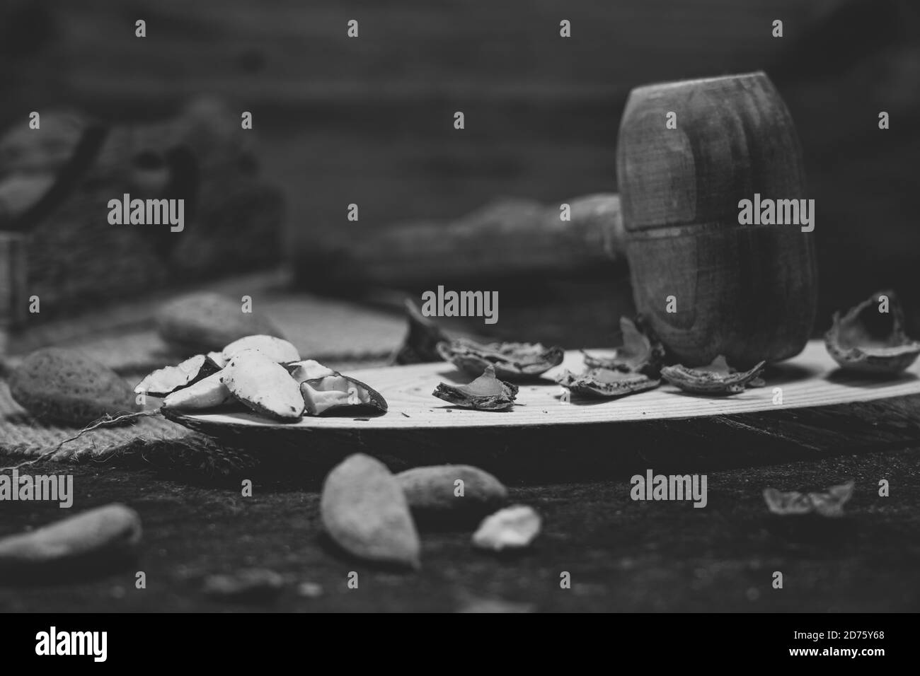 Grayscale closeup of broken nuts next to a mallet Stock Photo - Alamy