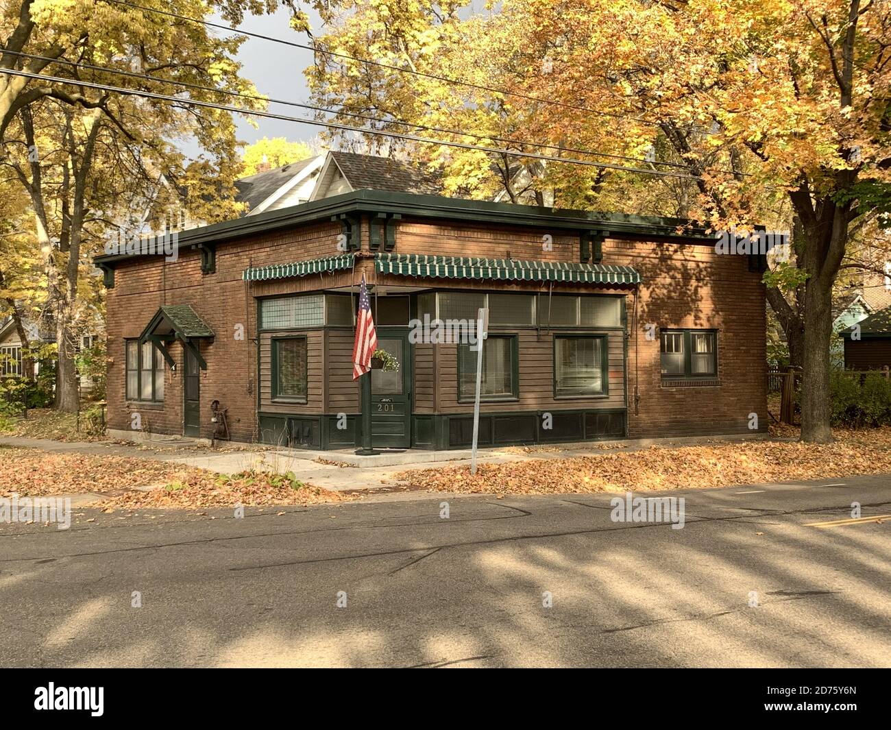 Beautiful autumn view and brick-made building with a US flag pole in ...