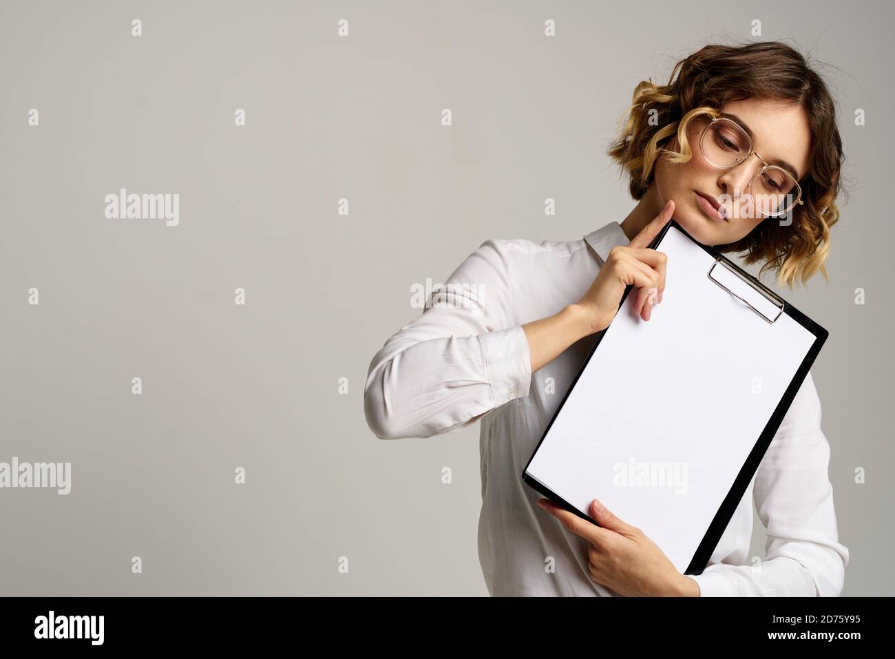 Business woman with folder of documents in hands on gray background ...