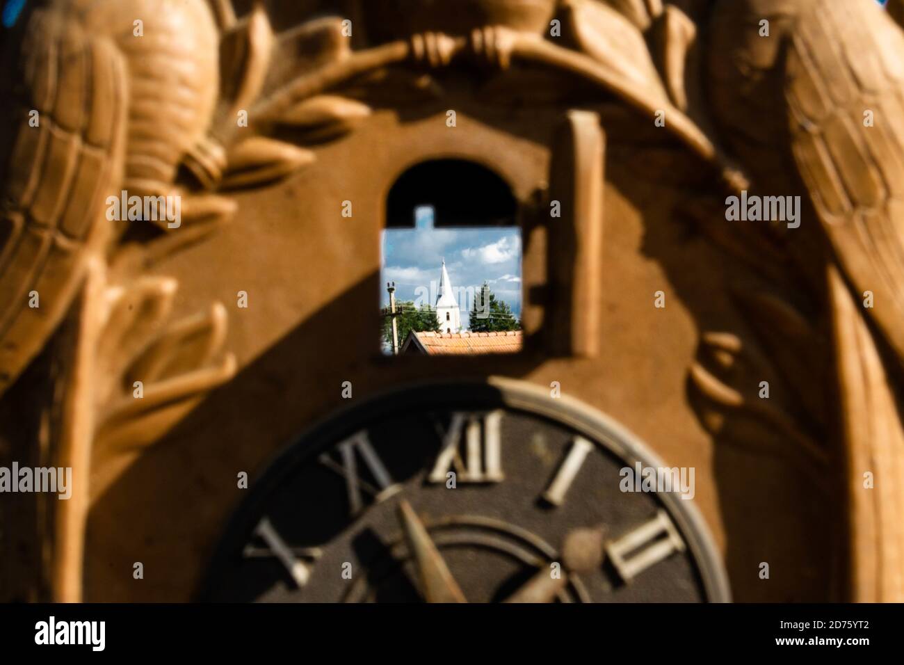 Bell tower visible through a small open door of a Cuckoo wooden clock ...