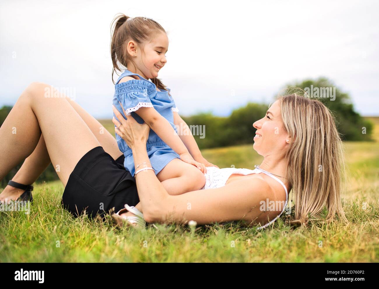 Happiness mother with her daughter lay on the ground Stock Photo - Alamy