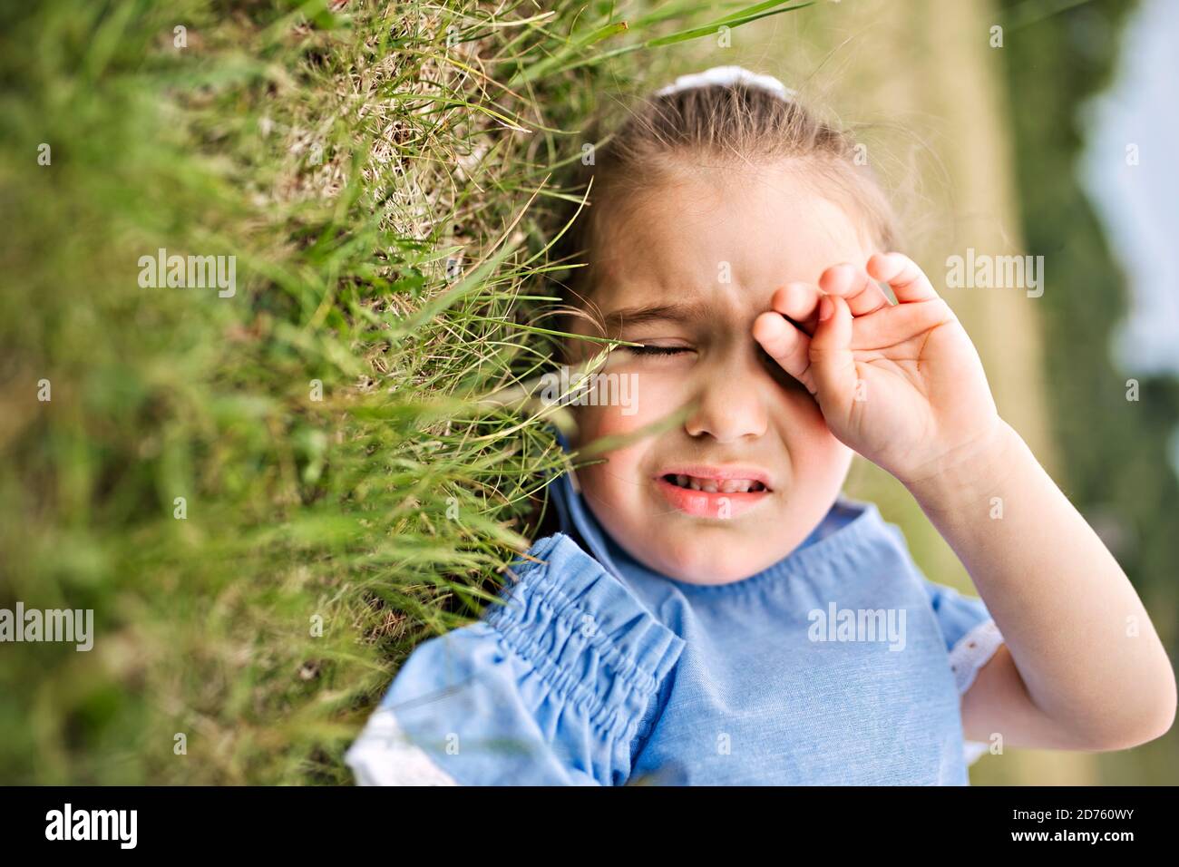 portrait of small sad girl lay on the ground Stock Photo - Alamy