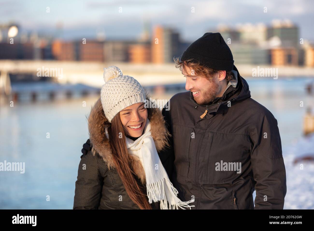 Happy winter friends couple laughing together walking in city outdoors ...