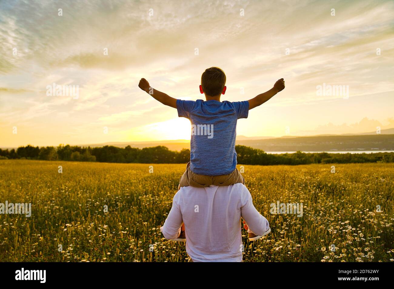 happy family of father and child on field at the sunset having fun ...