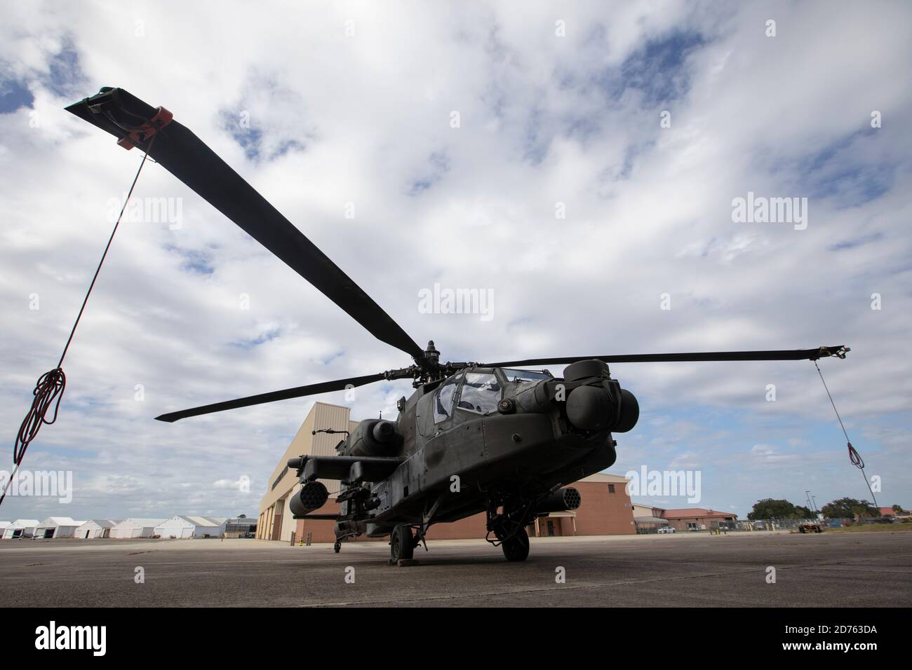 An AH-64 Apache helicopter sits outside of a hangar at Hunter Army ...
