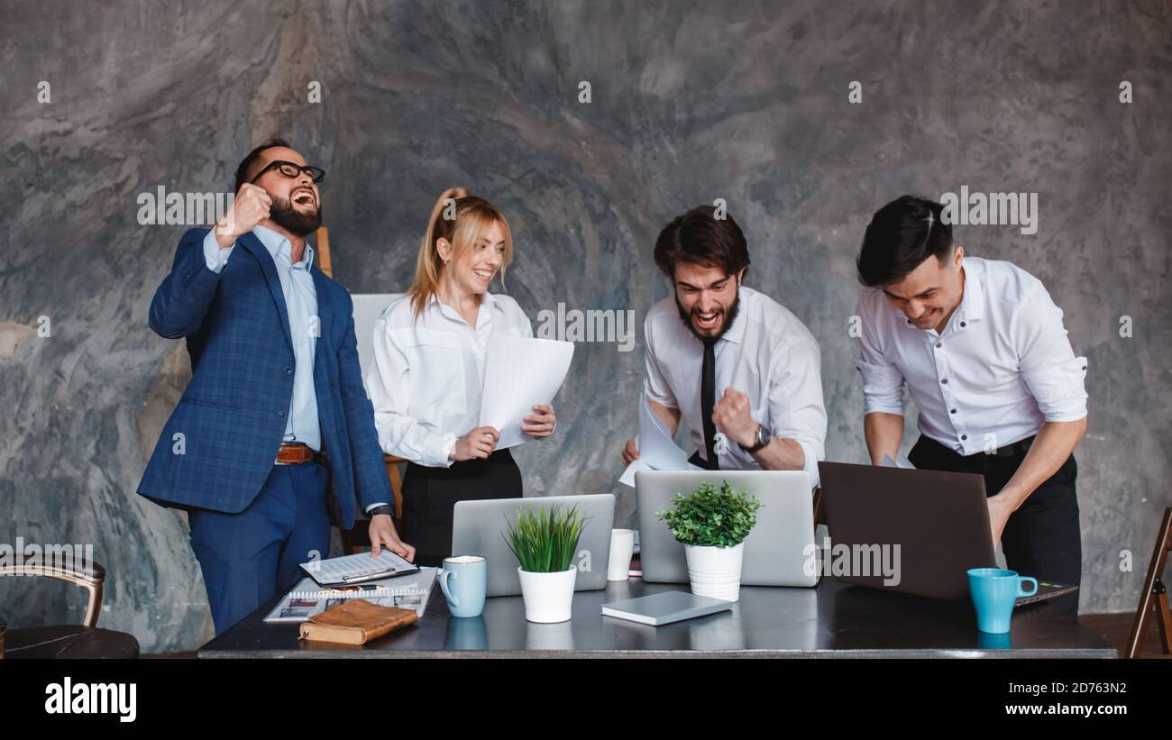 Euphoric excited business team celebrate corporate victory together in ...