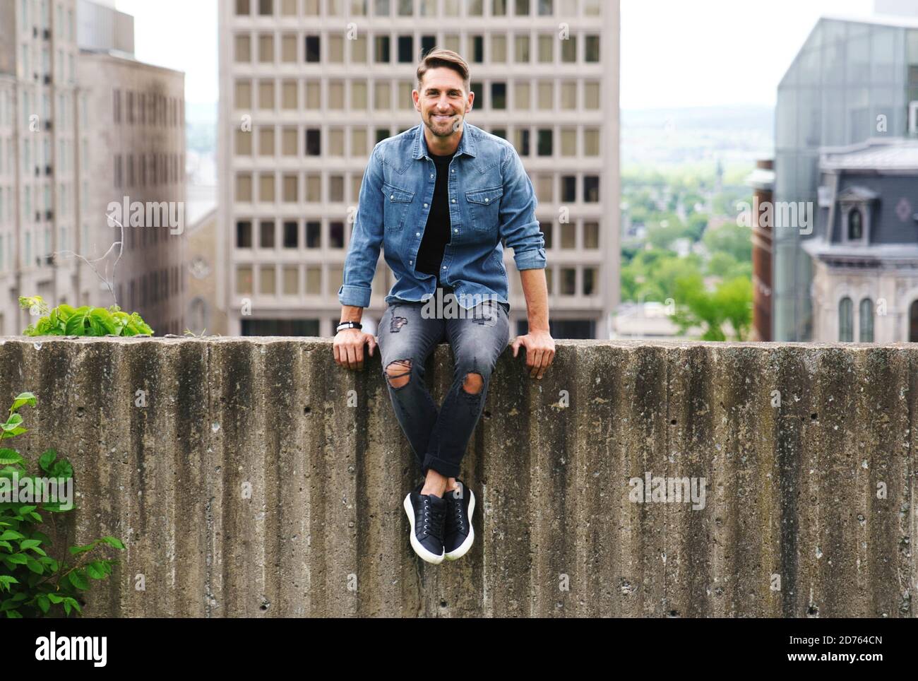 Fashionable guy having good time on the city background with building ...