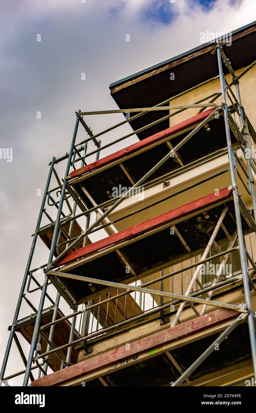 Vertical low angle shot of a building with a scaffolding metal frame ...