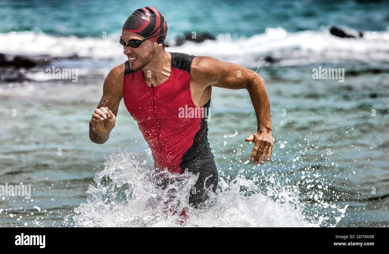Triathlon swimming man running out of water during ironman race. Male ...