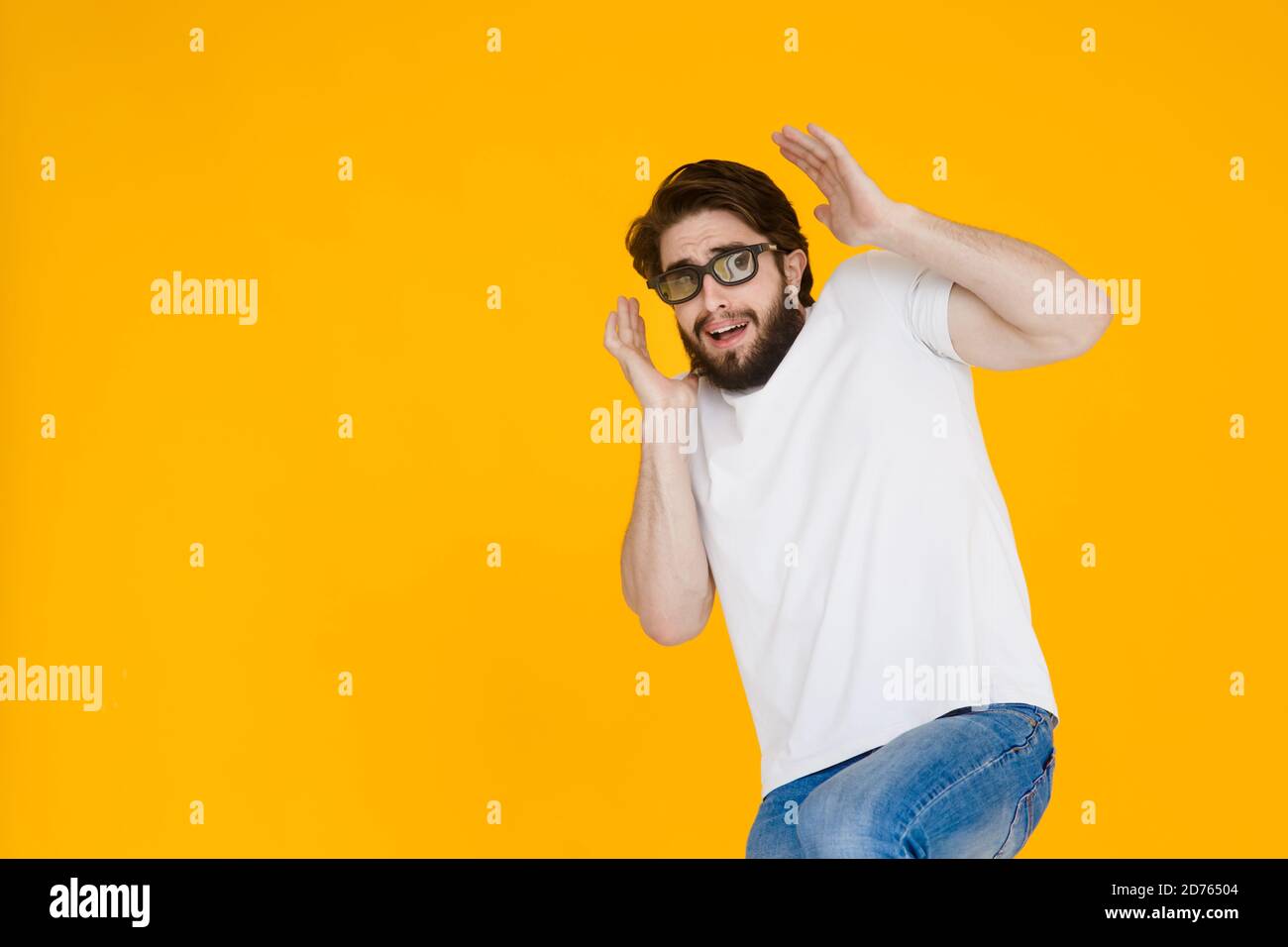 Portrait of a shaggy, bearded scared man in 3D glasses with an open ...