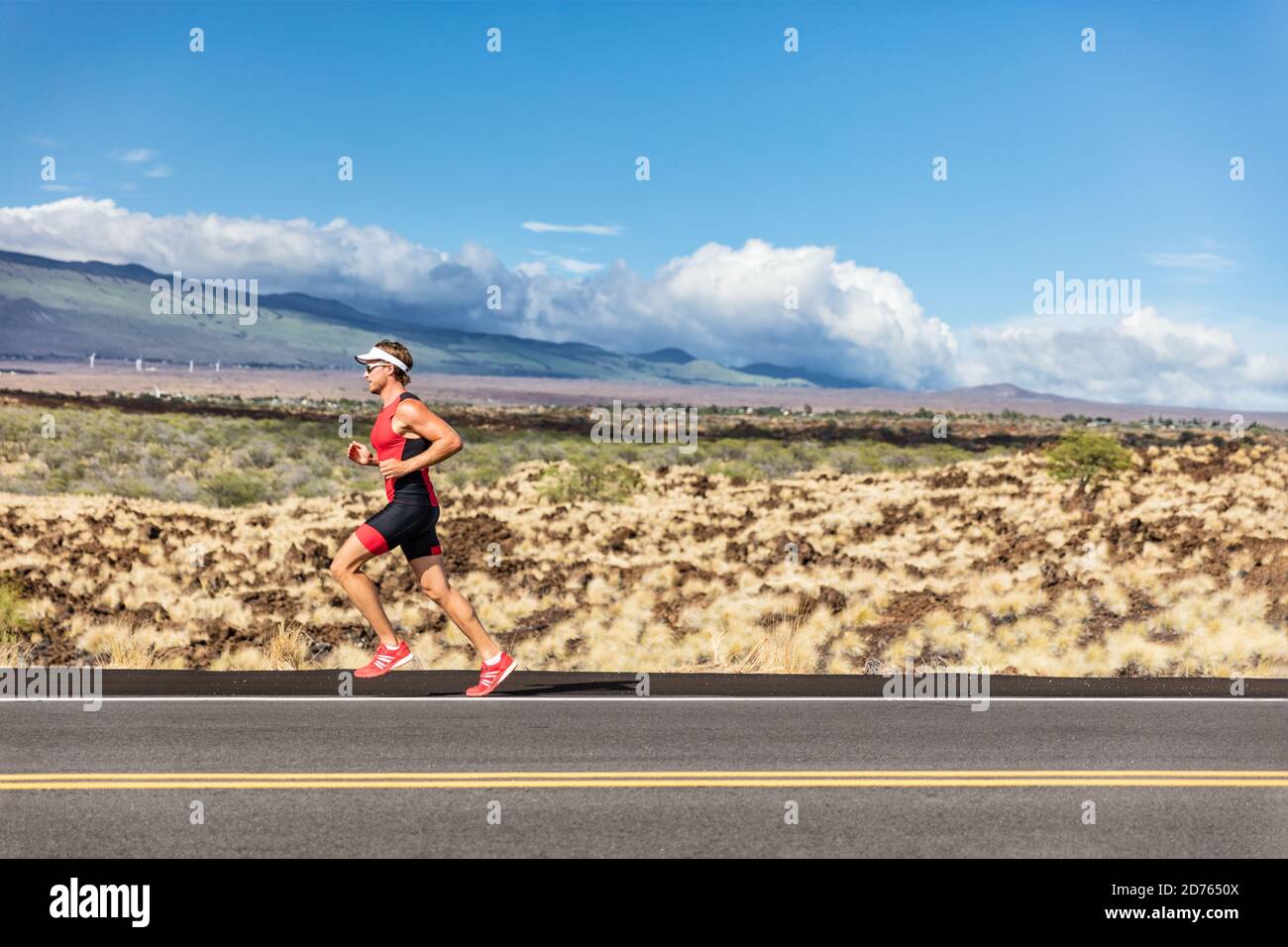 Triathlon runner triathlete man running on road wearing tri suit at ...