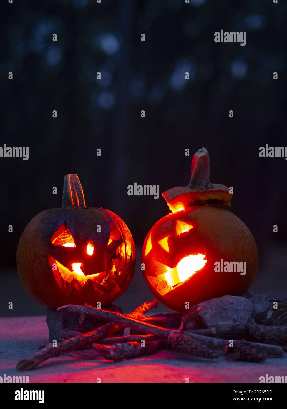 Vertical shot of two Halloween pumpkin lantern lighted up through the ...