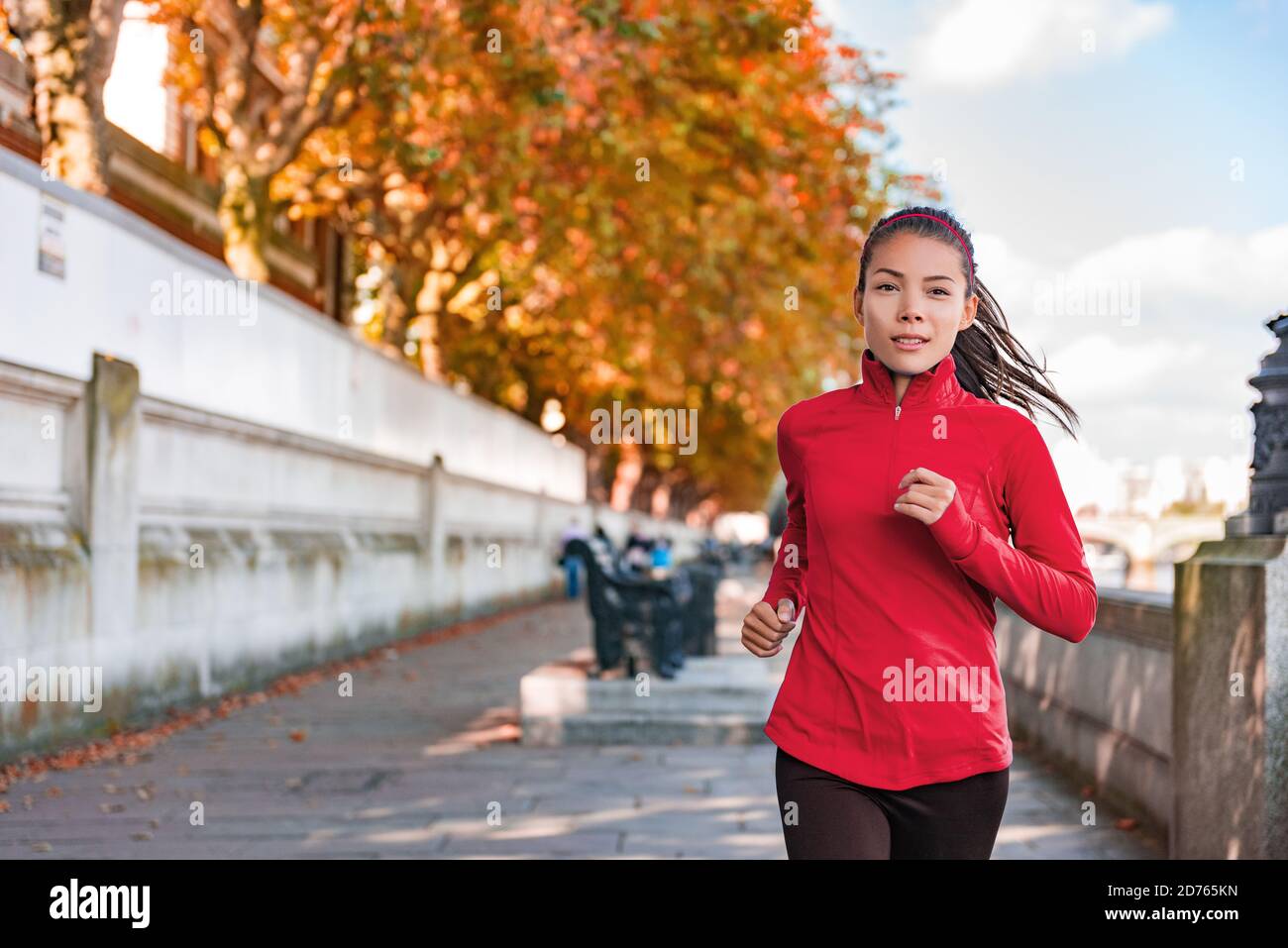 Woman running in autumn fall outdoor city street. Female runner ...