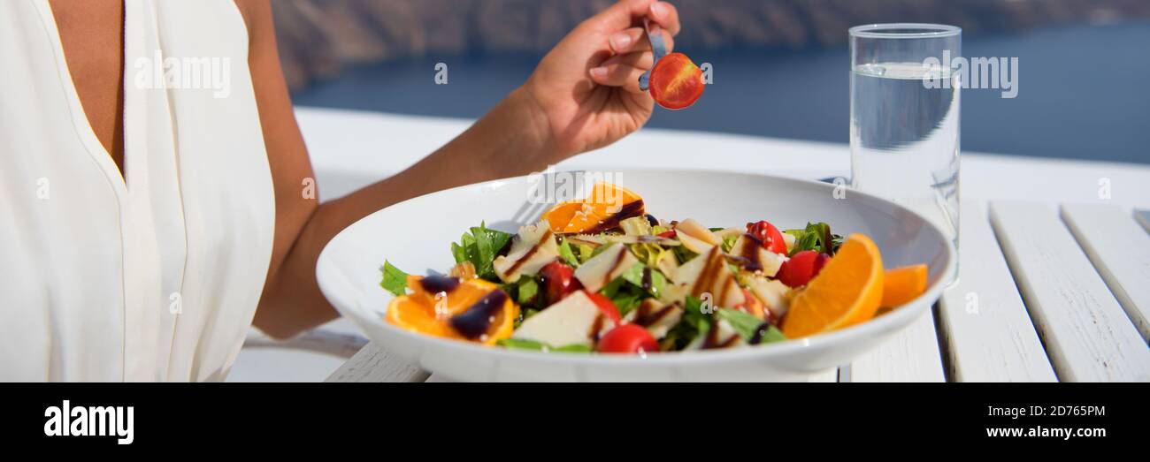 Healthy woman eating salad banner crop of diet meal at restaurant table ...