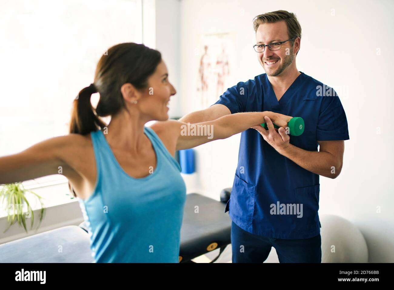 Male Physical Therapist Stretching a Female Patient Slowly Stock Photo ...
