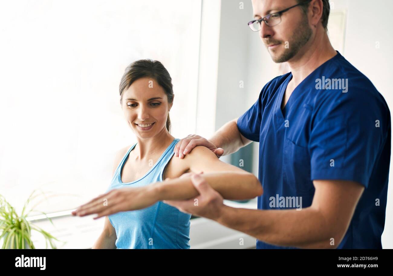 Male Physical Therapist Stretching a Female Patient Slowly Stock Photo ...