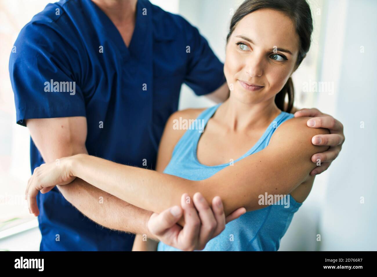 Male Physical Therapist Stretching a Female Patient Slowly Stock Photo ...