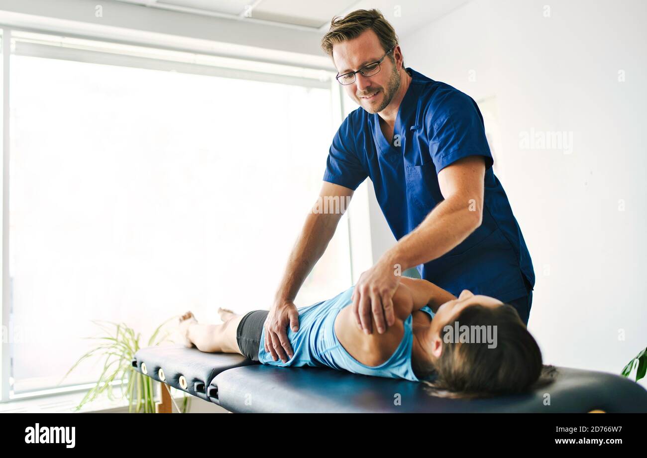 Male Physical Therapist Stretching a Female Patient Slowly Stock Photo ...