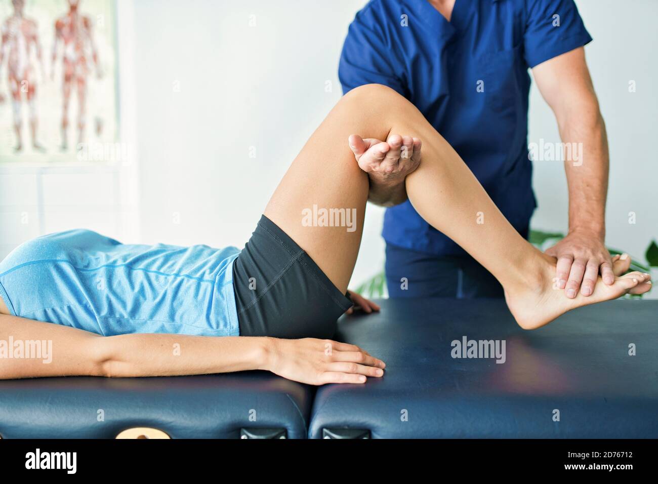 Male Physical Therapist Stretching a Female Patient Stock Photo - Alamy