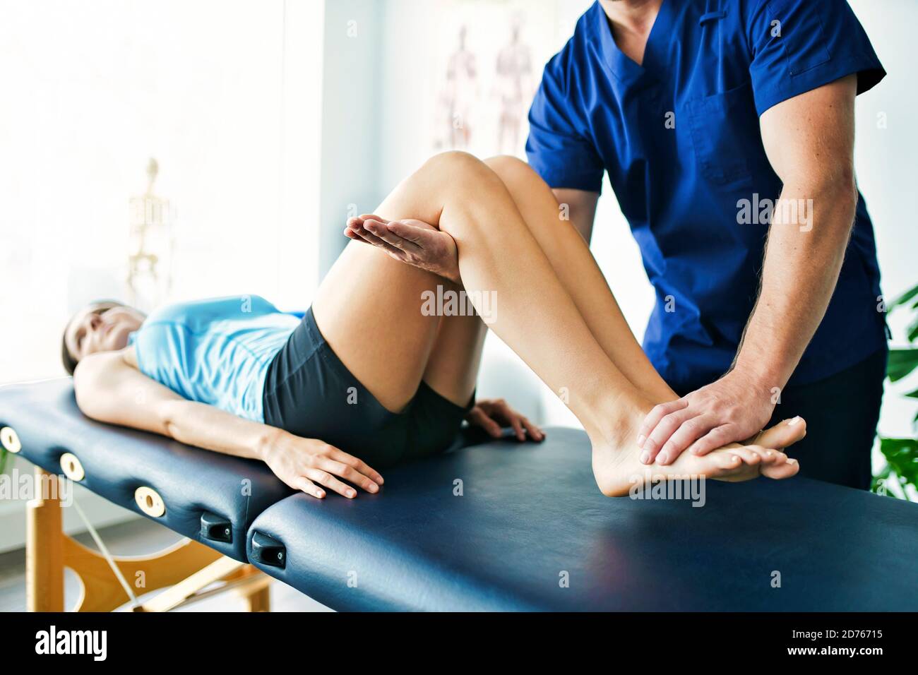 Male Physical Therapist Stretching a Female Patient Stock Photo - Alamy
