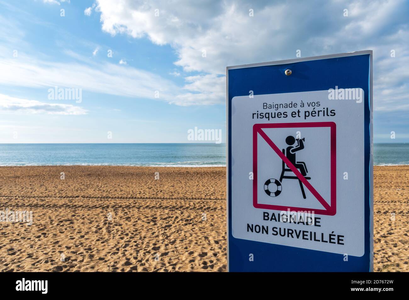 Warning sign written in French indicating "unpatrolled beach" on the ...
