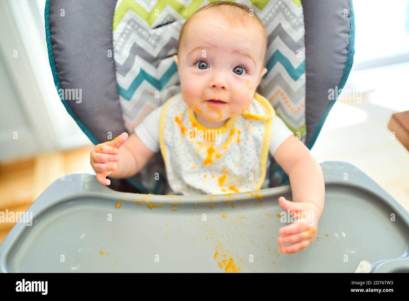 A happy little cute baby girl with mash food everywhere Stock Photo - Alamy