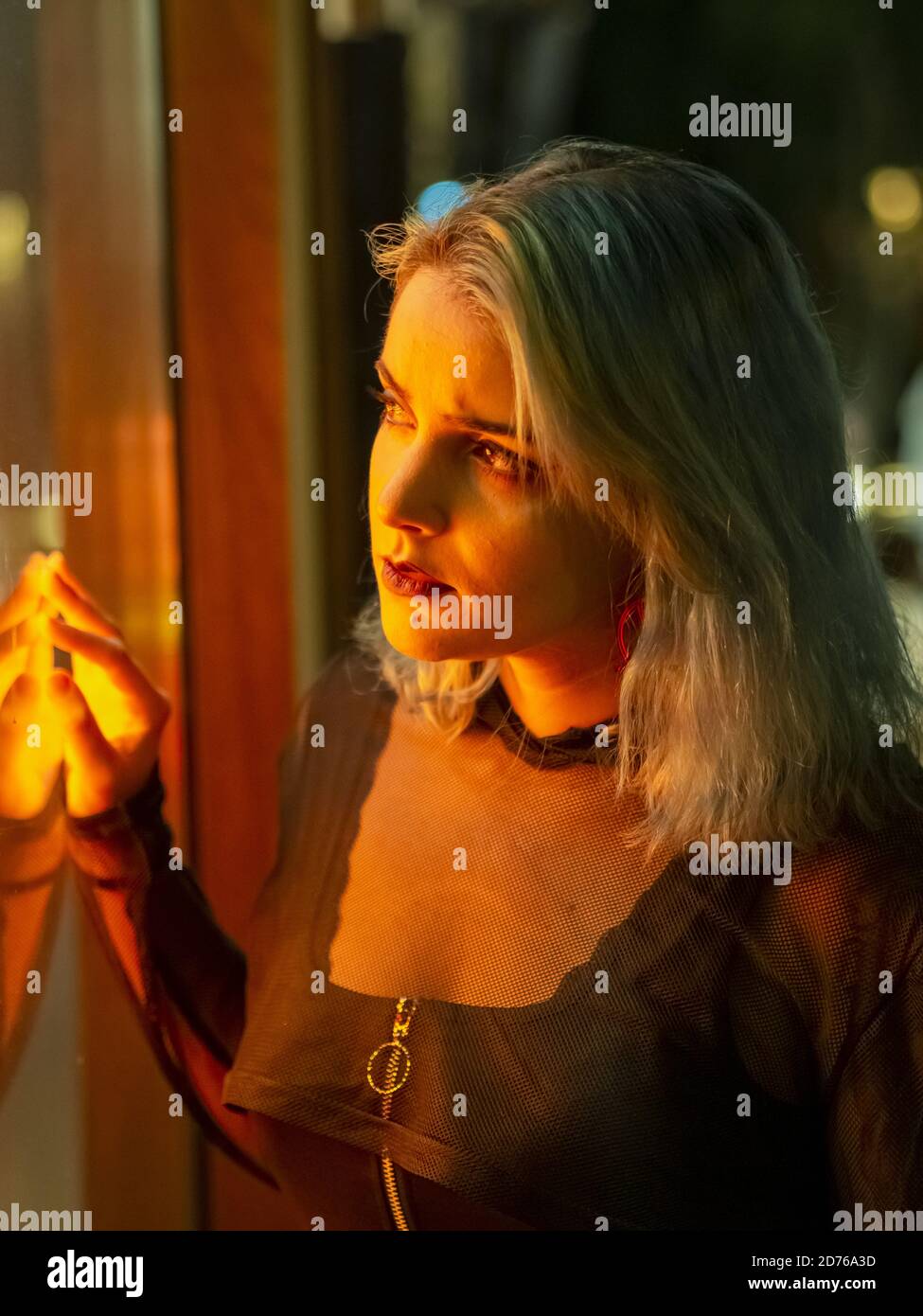 Shallow focus of a young female with blue hair posing near the led ...