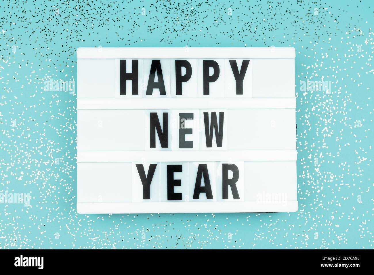 Happy new year light box with on blue background with scattered ...