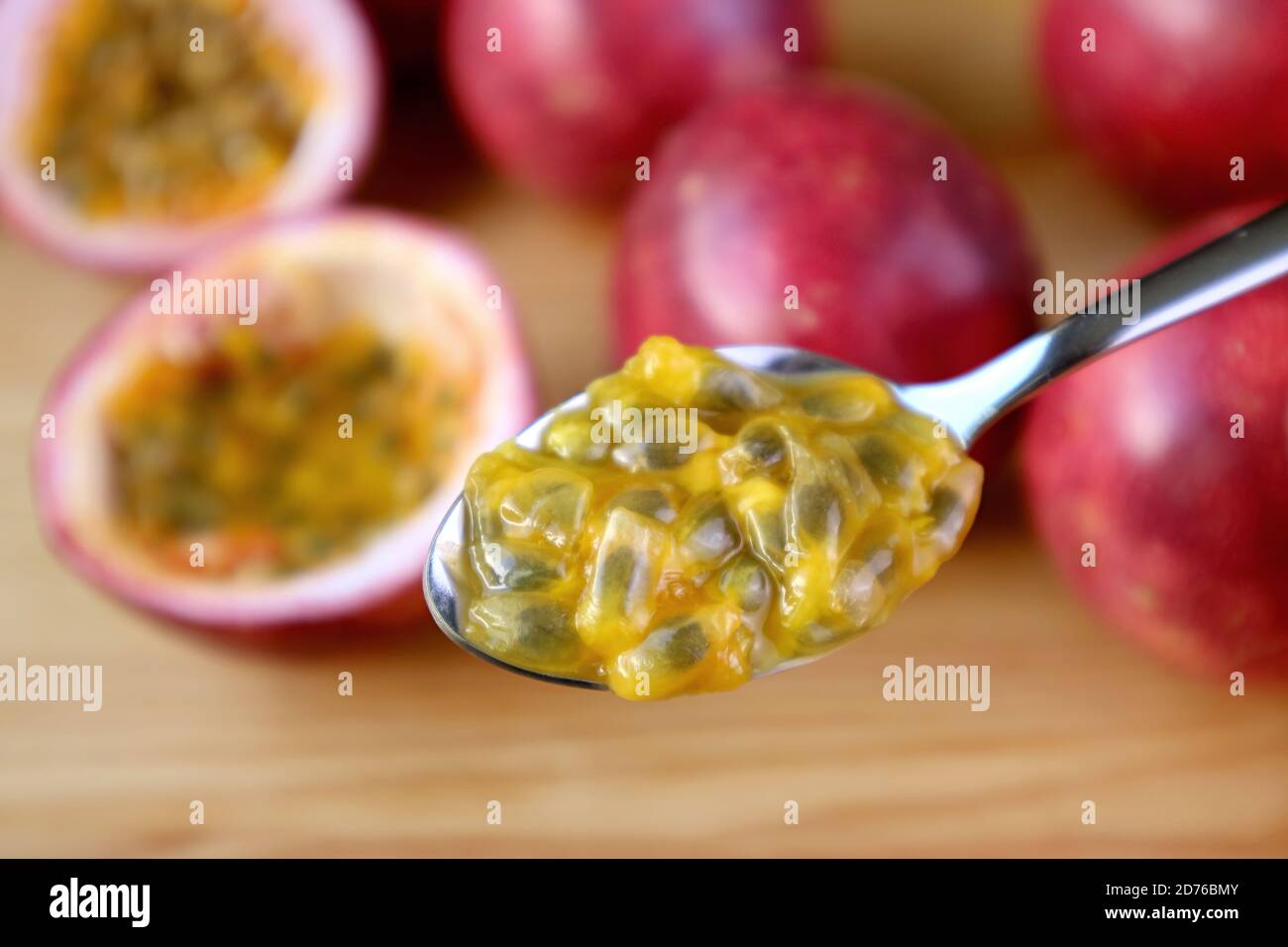 Closeup of the flesh and seeds of ripe passion fruit on a spoon with ...