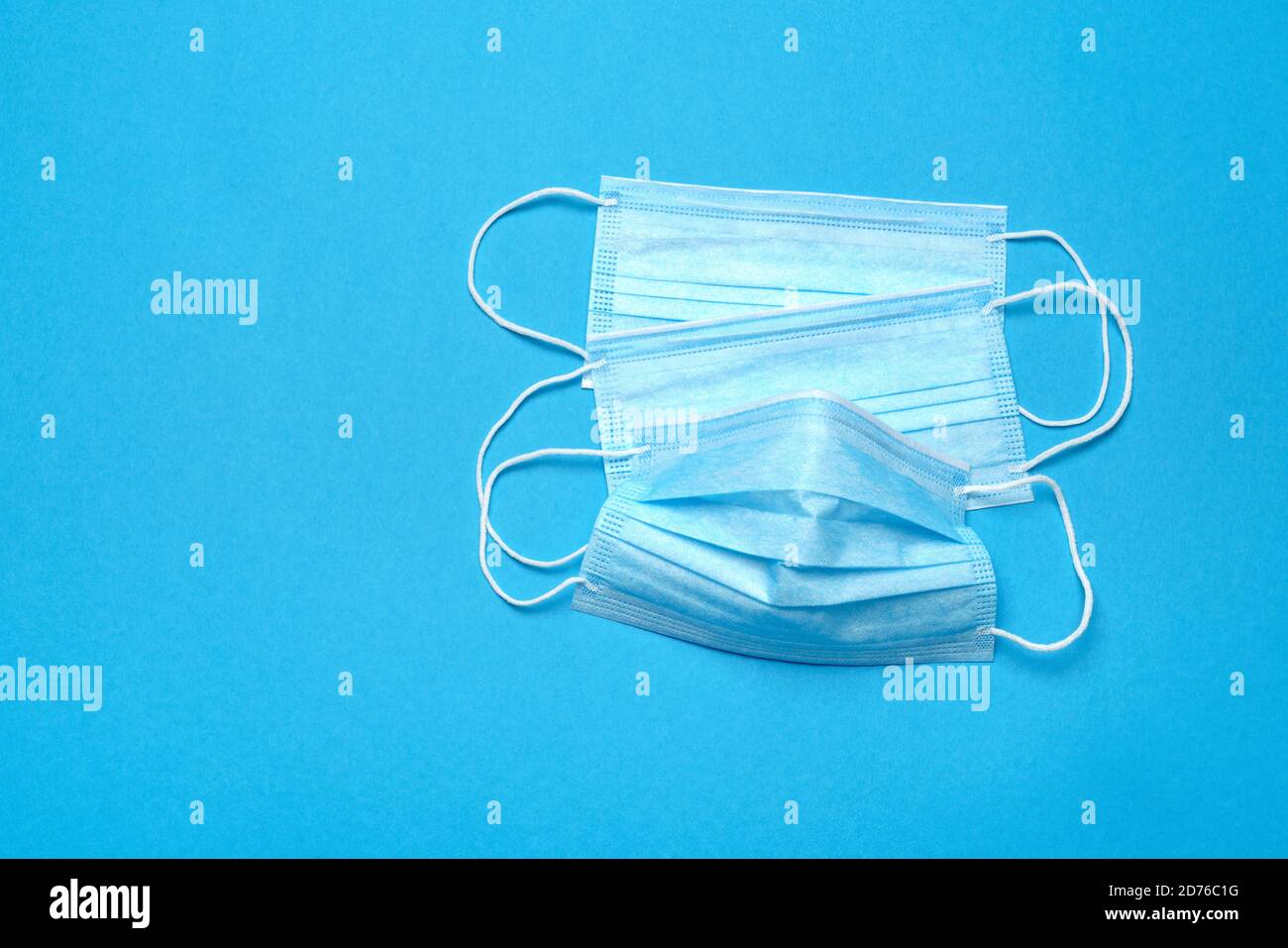 Stack of Disposable blue medical face masks on blue background Stock ...