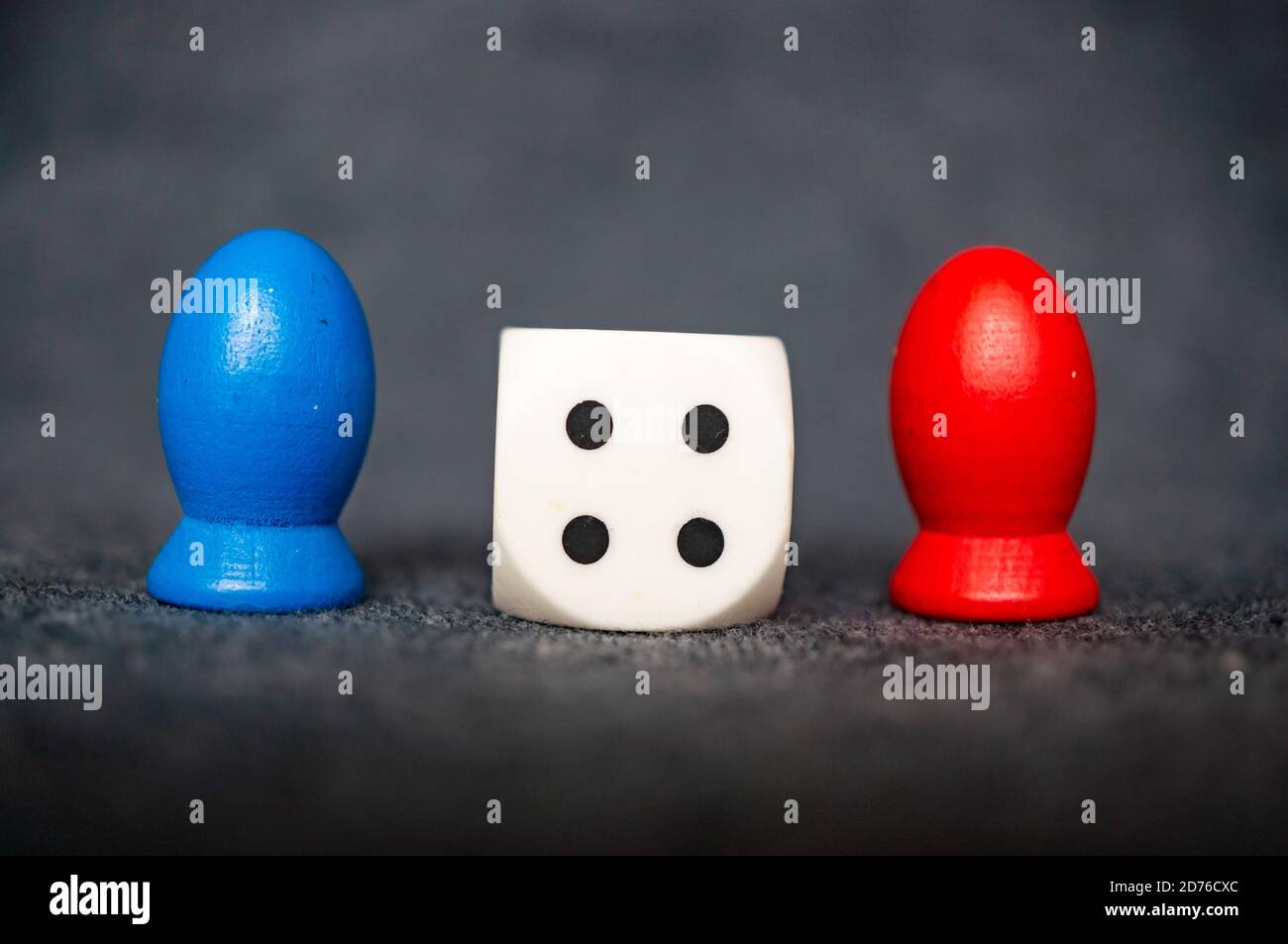 Closeup of dice roll four with red and blue wooden figures on both ...