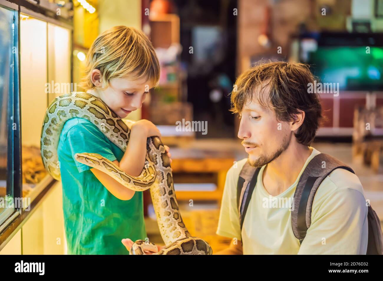 Smiling boy and his father holding python in hands Stock Photo - Alamy
