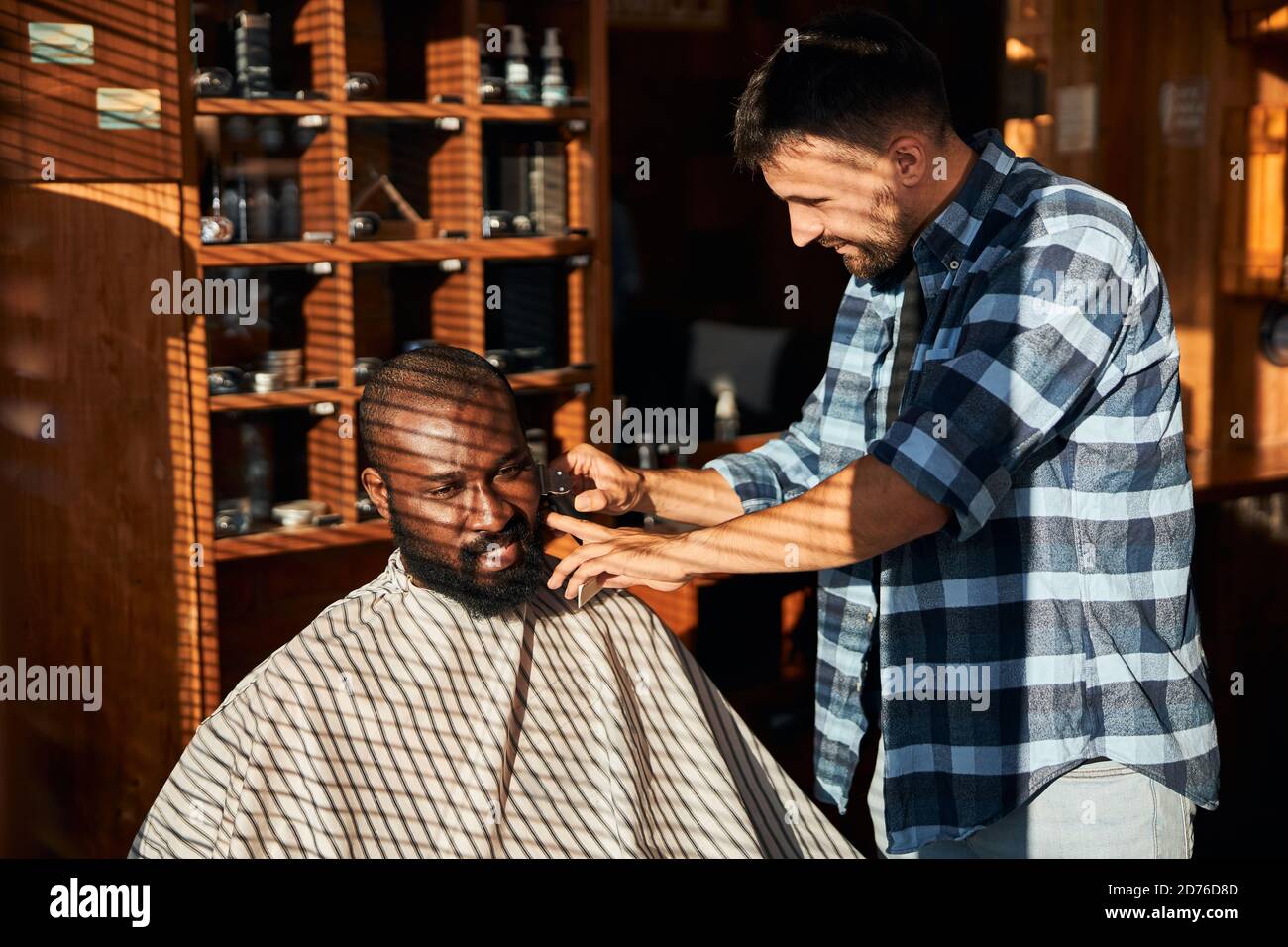 Male barber shaving client beard with electric razor Stock Photo - Alamy