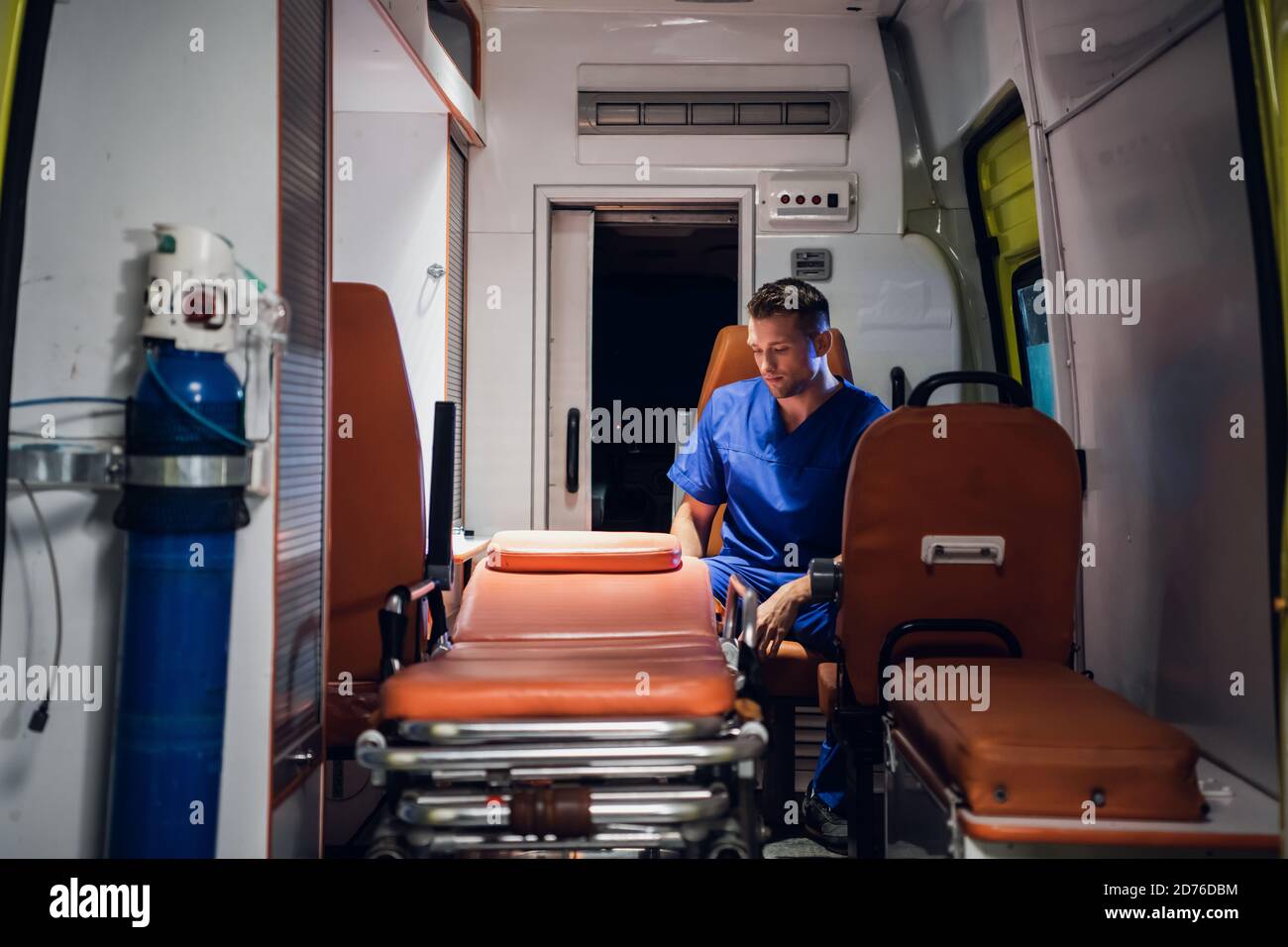 Young doctor in medical uniform sitting in the ambulance car Stock ...