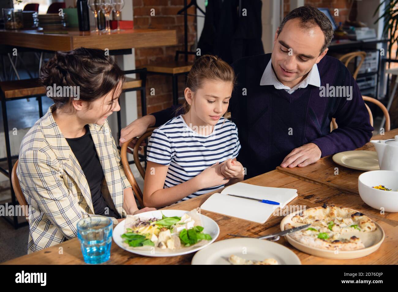 Young parents helping their daughter with her homework Stock Photo - Alamy