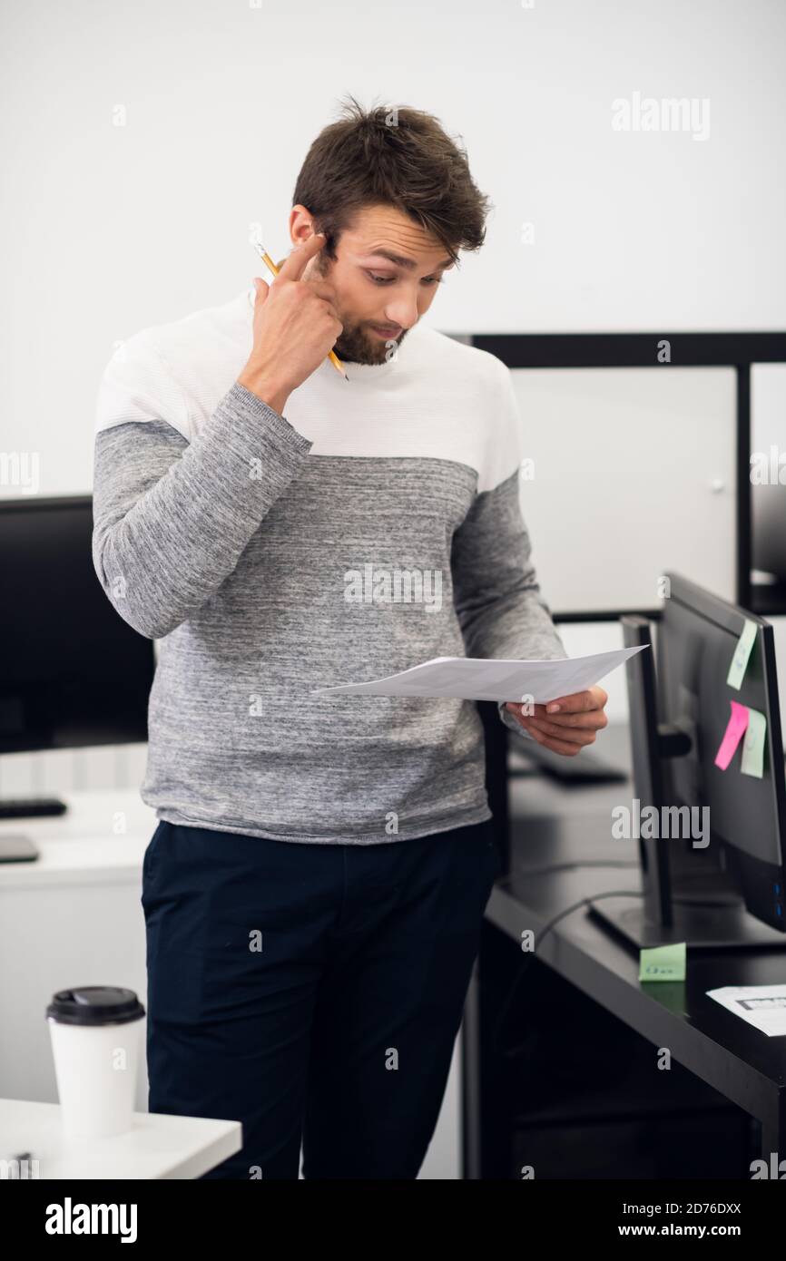 A portrait of a young office worker puzzled with something Stock Photo ...