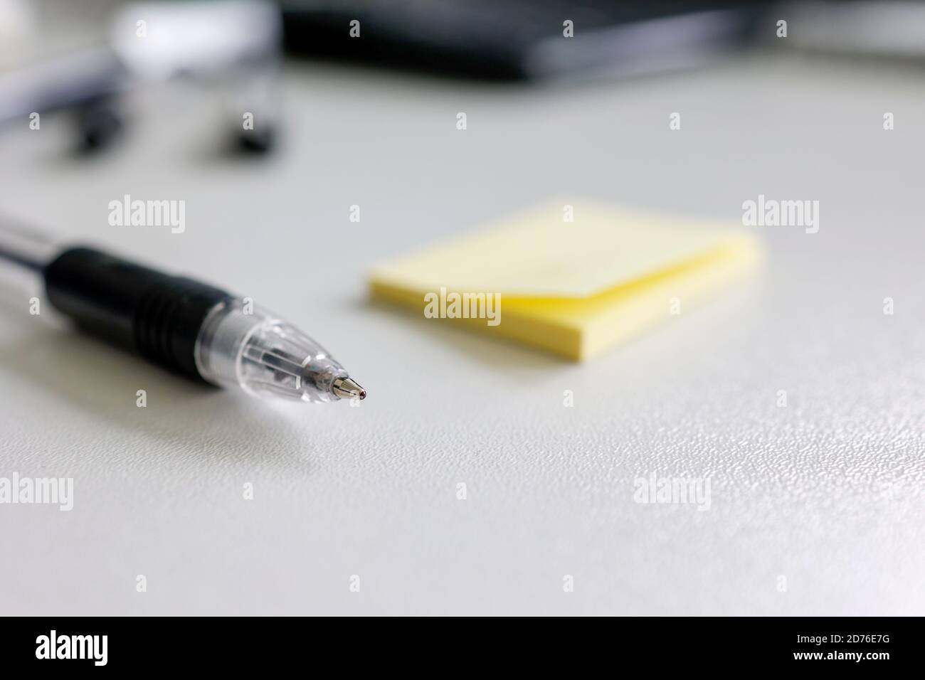 Close up of ballpoint pen and post it pad on desk Stock Photo - Alamy