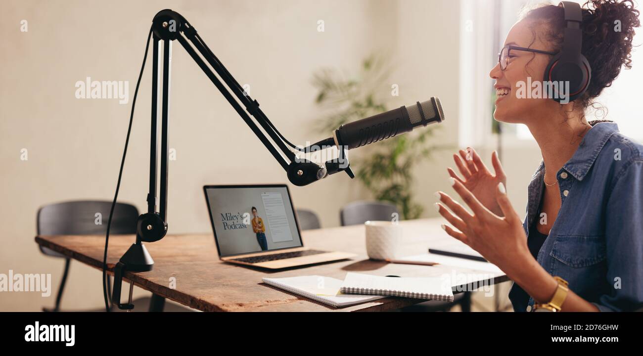 Young woman making a podcast from home studio. Female recording a ...