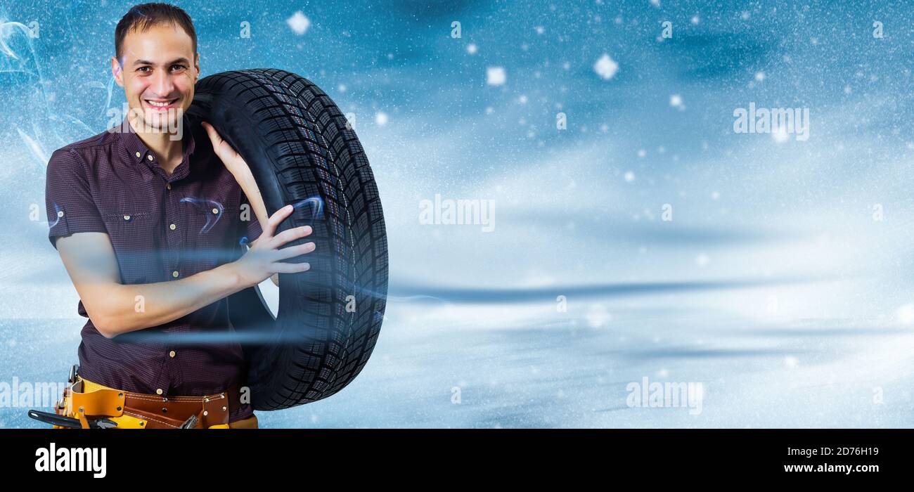 car mechanic carrying tire on blue background. happy man smiling amd ...