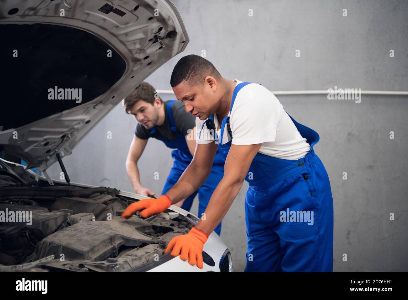 Two experienced engineers repair a broken car engine Stock Photo - Alamy