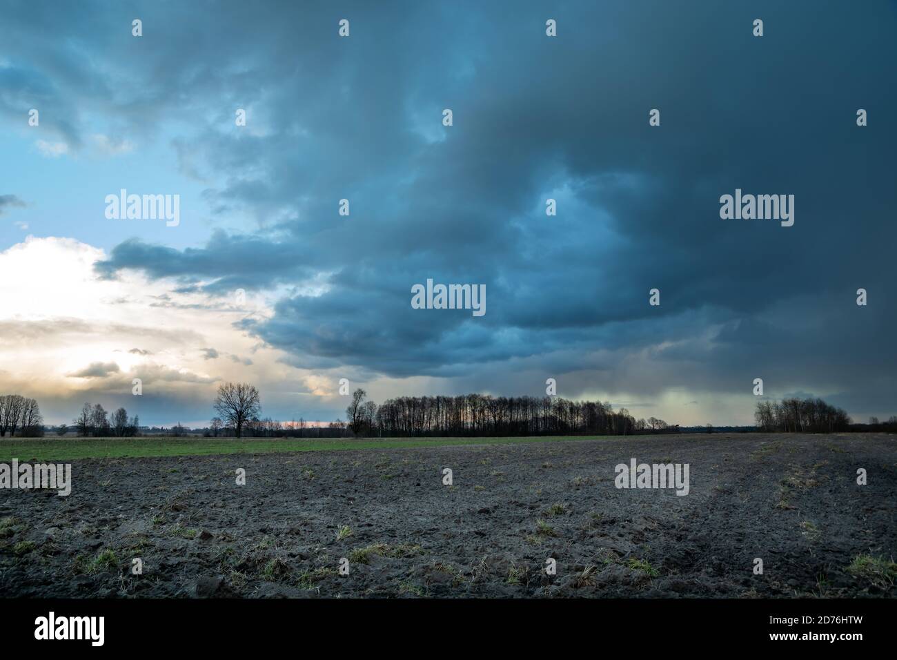 Dark rain cloud over a plowed field Stock Photo - Alamy