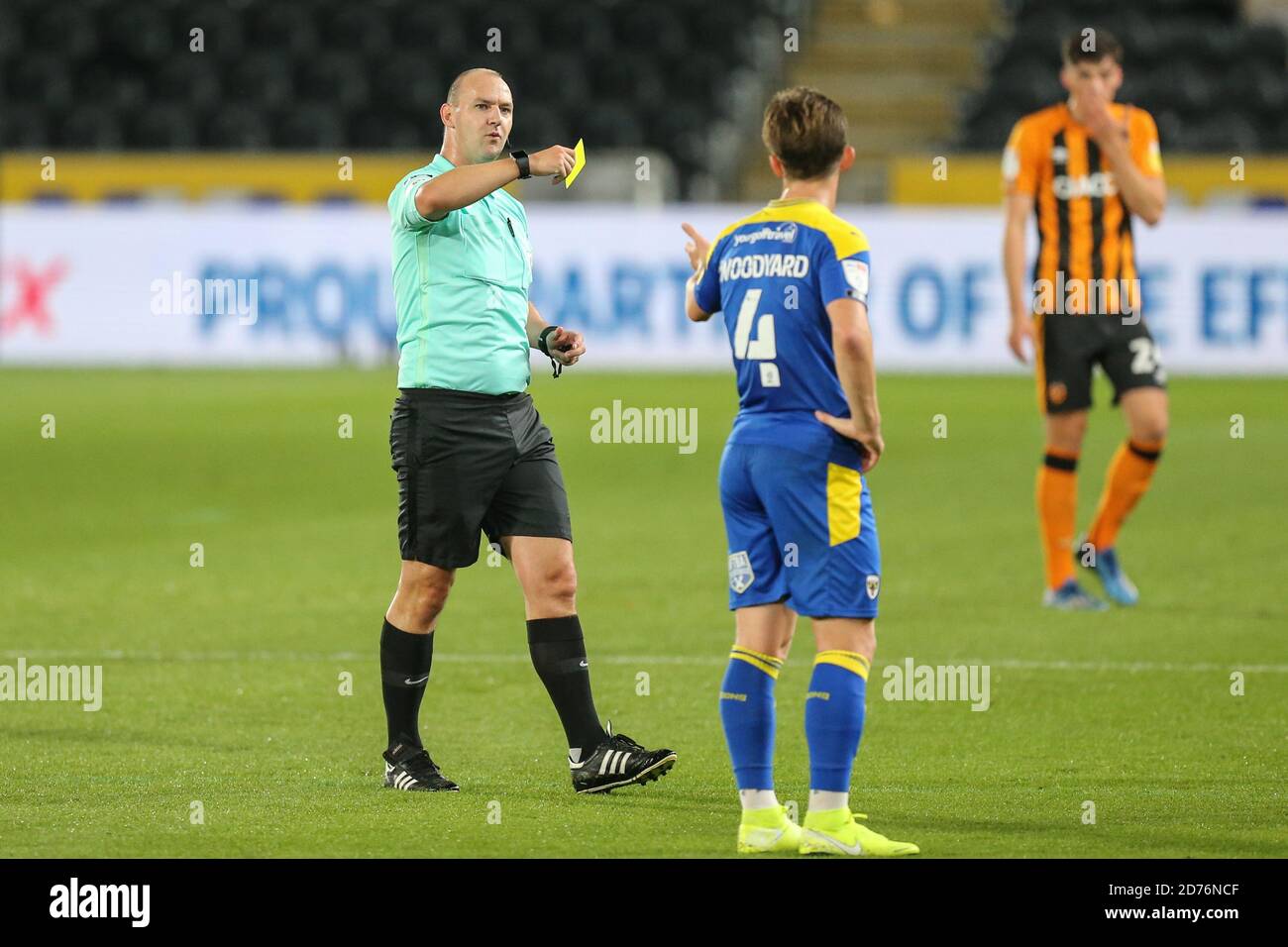 Alex Woodyard (4) of AFC Wimbledon is booked by referee Robert Madley ...