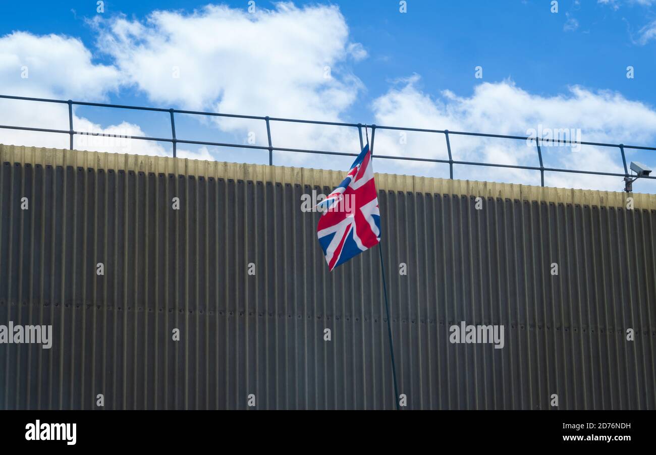 british flag in front of commercial building with blue sky and white ...