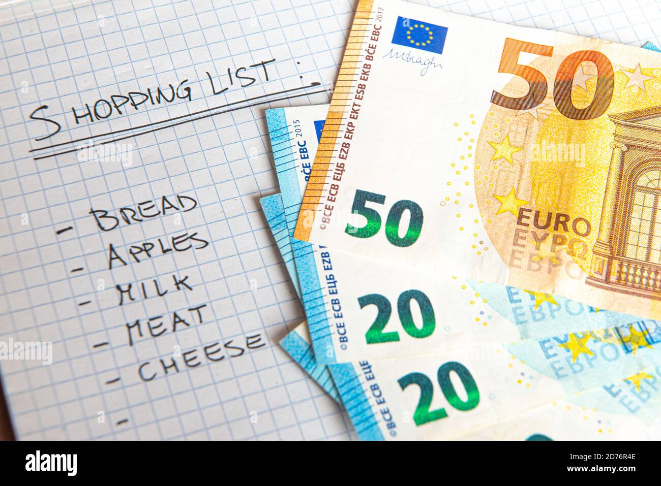 Notepad with text "shopping list", list of goods to buy, and money next ...