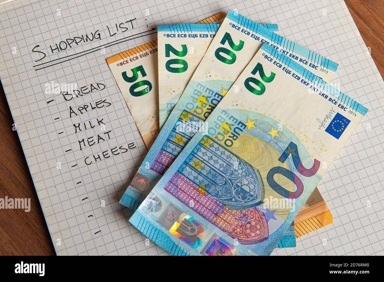 Notepad with text "shopping list", list of goods to buy, and money next ...