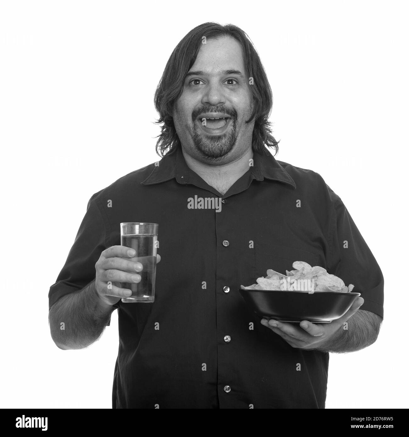 Happy fat bearded Caucasian man smiling while holding bowl of chips and ...