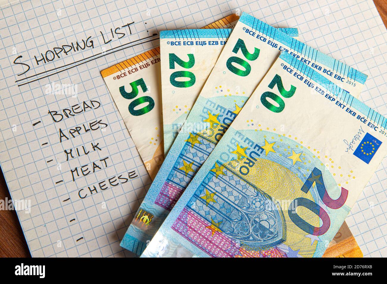 Notepad with text "shopping list", list of goods to buy, and money next ...