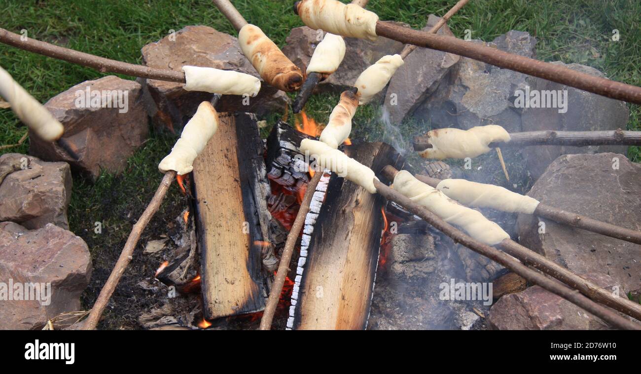 Making stick bread around the campfire Stock Photo - Alamy