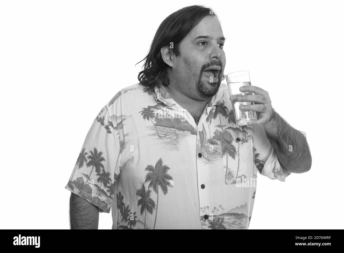 Fat Caucasian man drinking glass of water looking away Stock Photo - Alamy