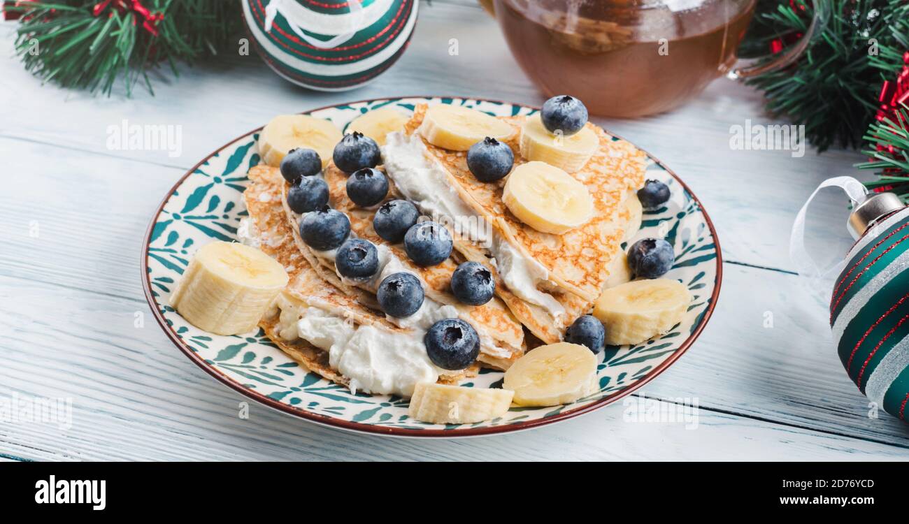 Christmas tree shaped crepes with quark, blueberry Stock Photo - Alamy